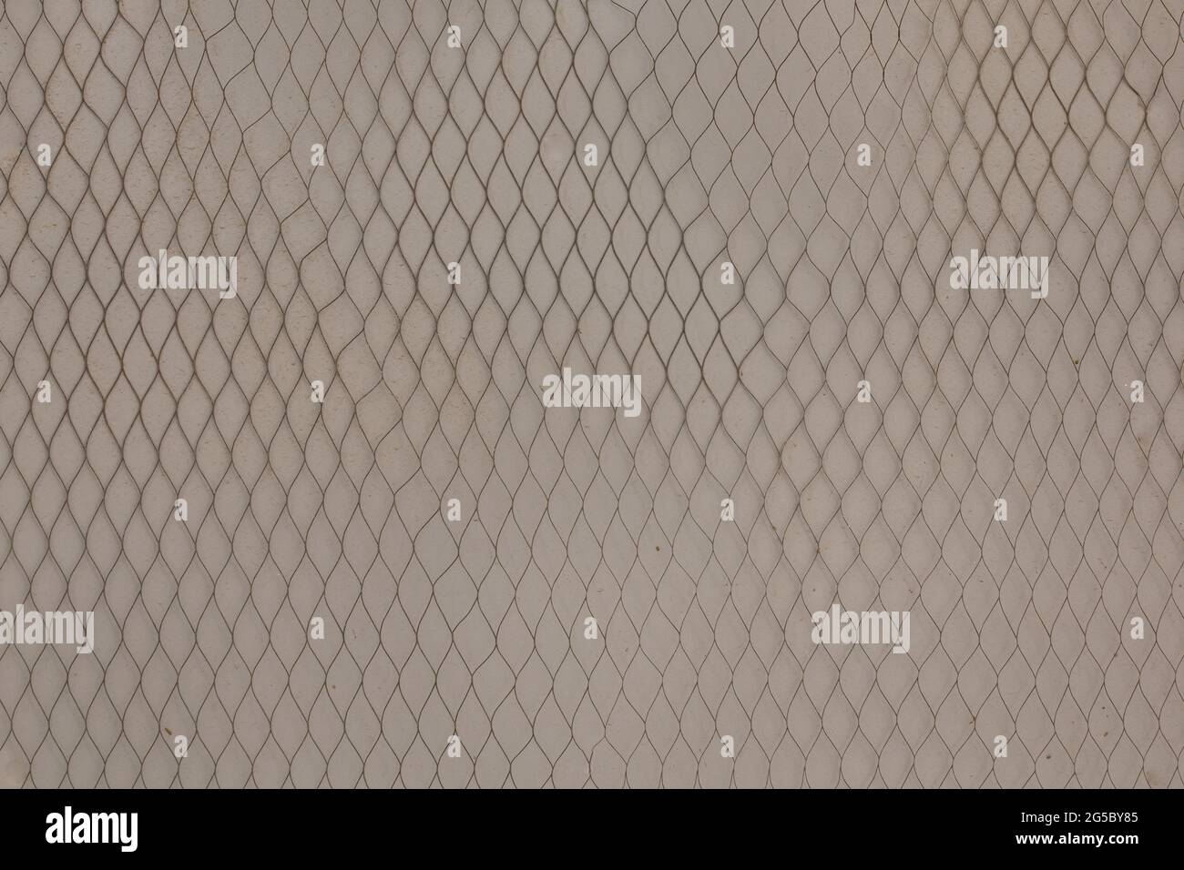 metal net on dirty light grey wall, background and texture Stock Photo ...
