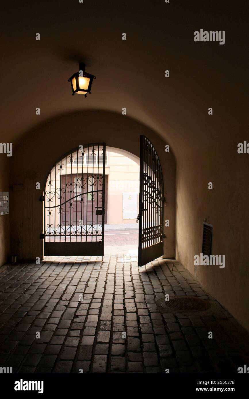 ancient gate arch with iron ornamented door on cobbled stones Stock ...