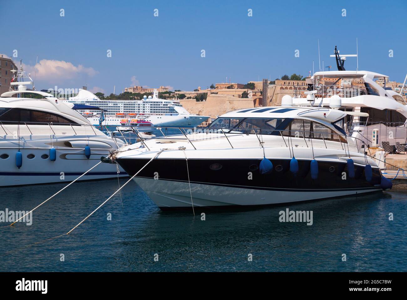 Luxury motor yachts are moored in marina on a sunny day. Valletta ...