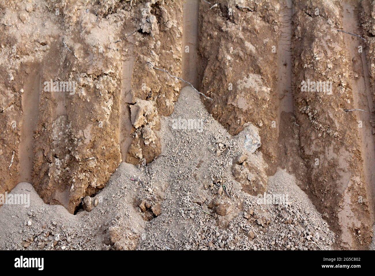 Dry dirt mixed with small grain sand in freshly dig ditch at local ...