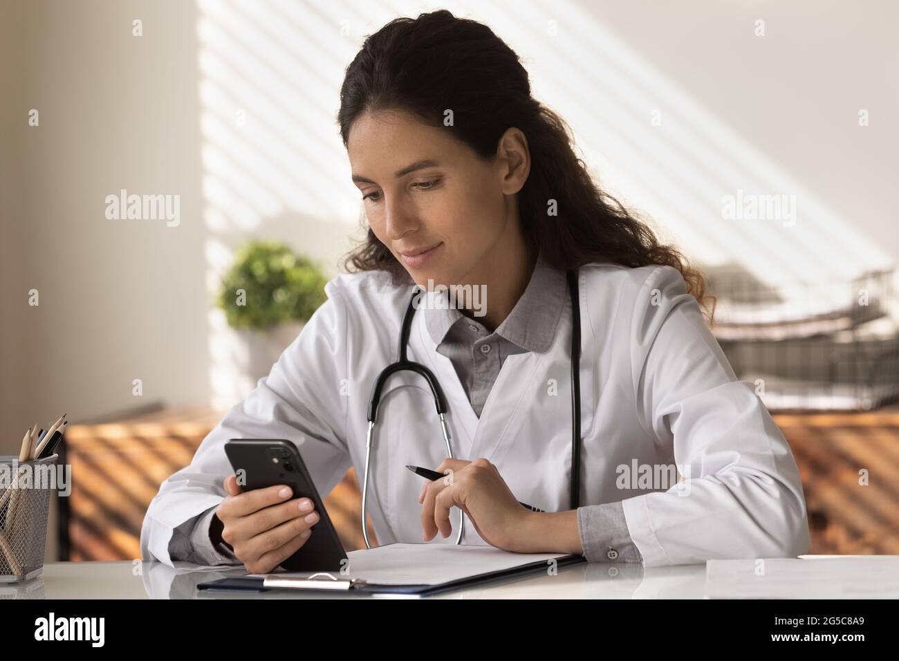Female doctor work in clinic using modern cellphone Stock Photo - Alamy