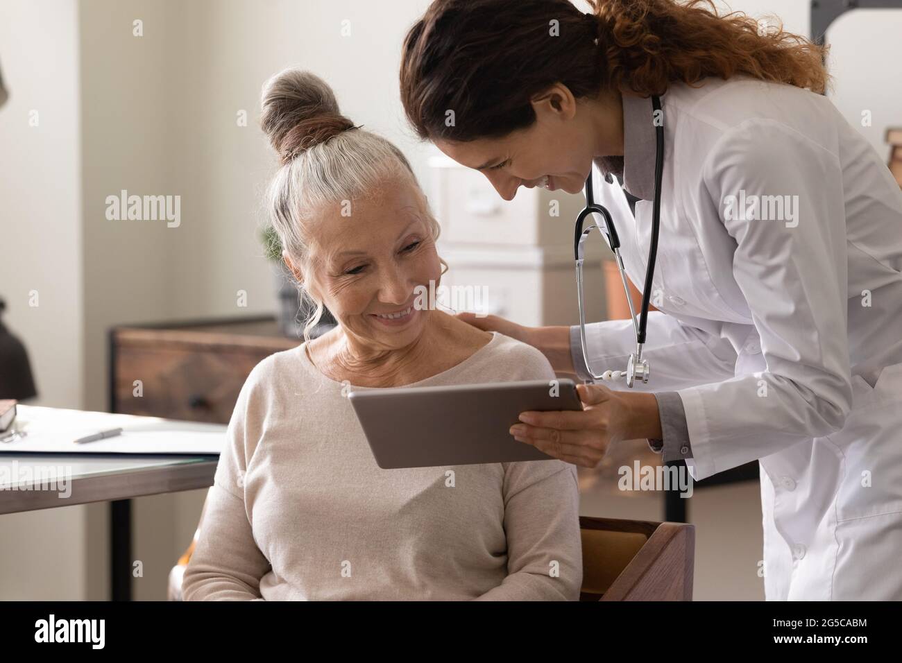 Female doctor use tablet at consultation with mature patient Stock ...