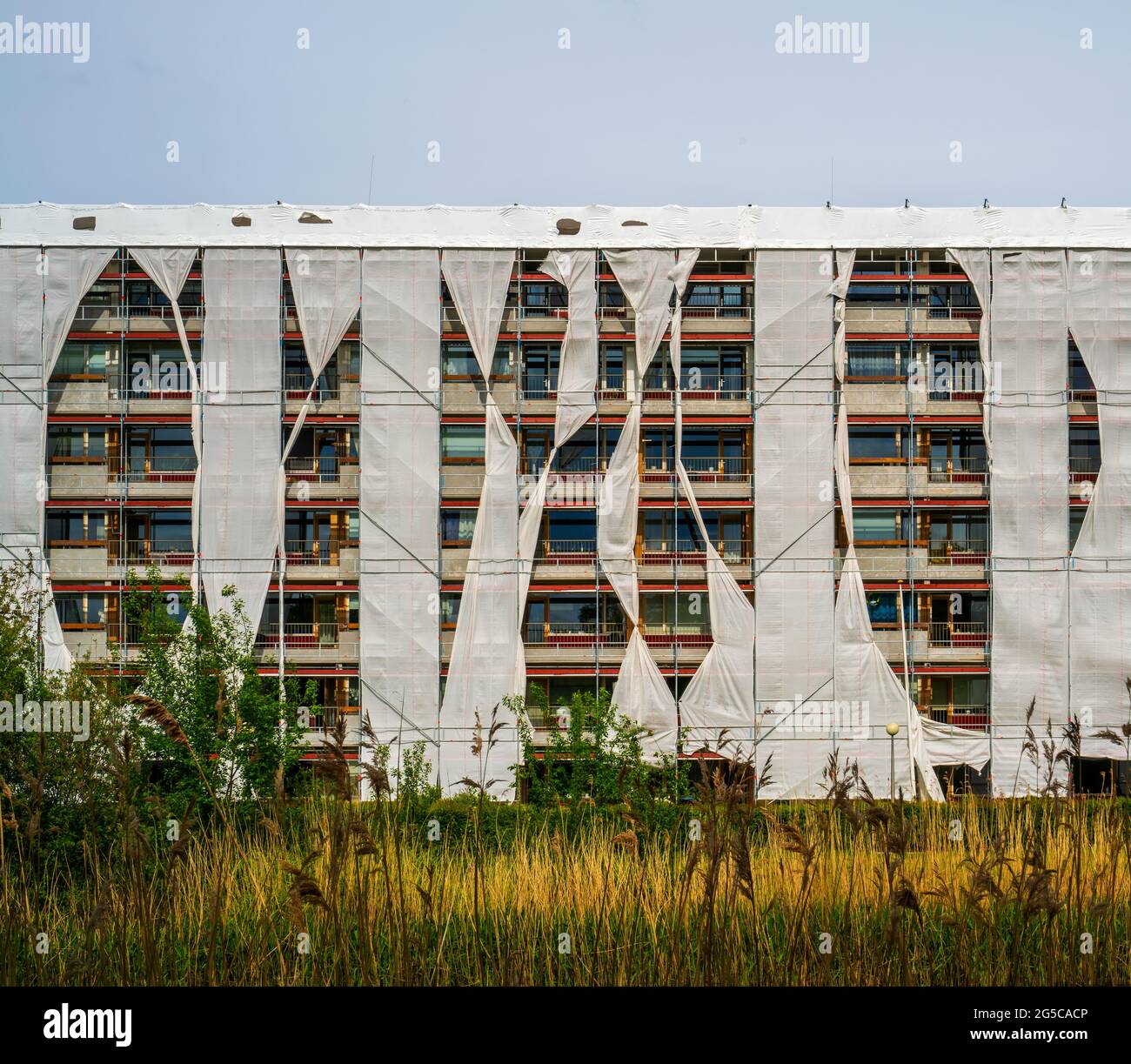 Apartment building packed in scaffoldings and covers Stock Photo - Alamy