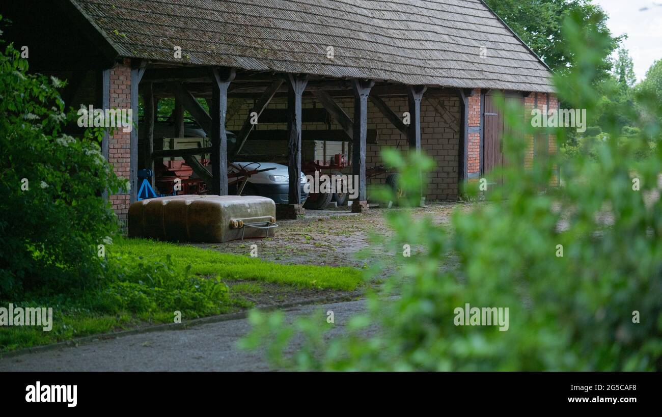 Rustic open storage building seen through blurred trees Stock Photo - Alamy