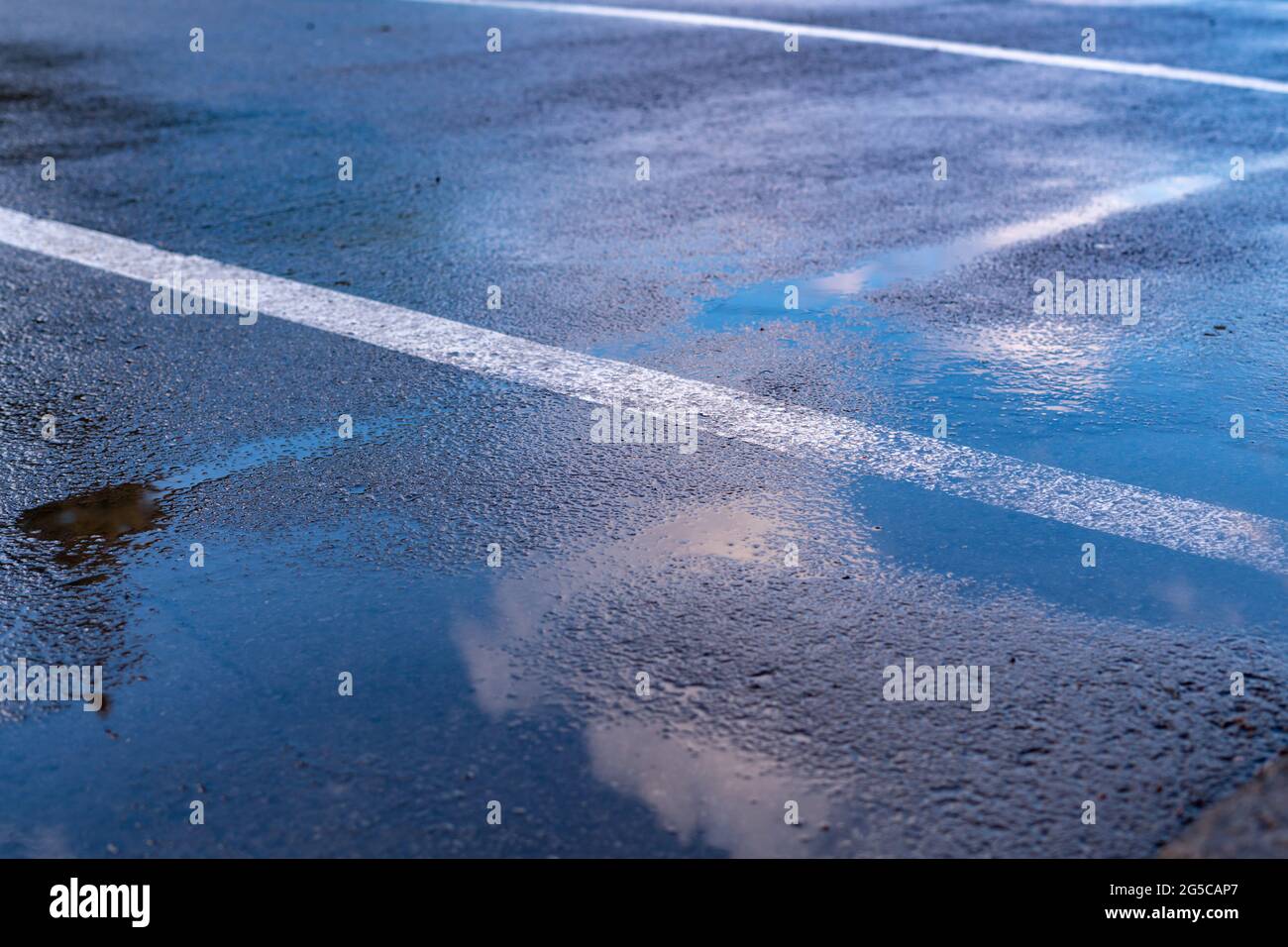 close up wet roadway traffic territory with puddles after the rain ...