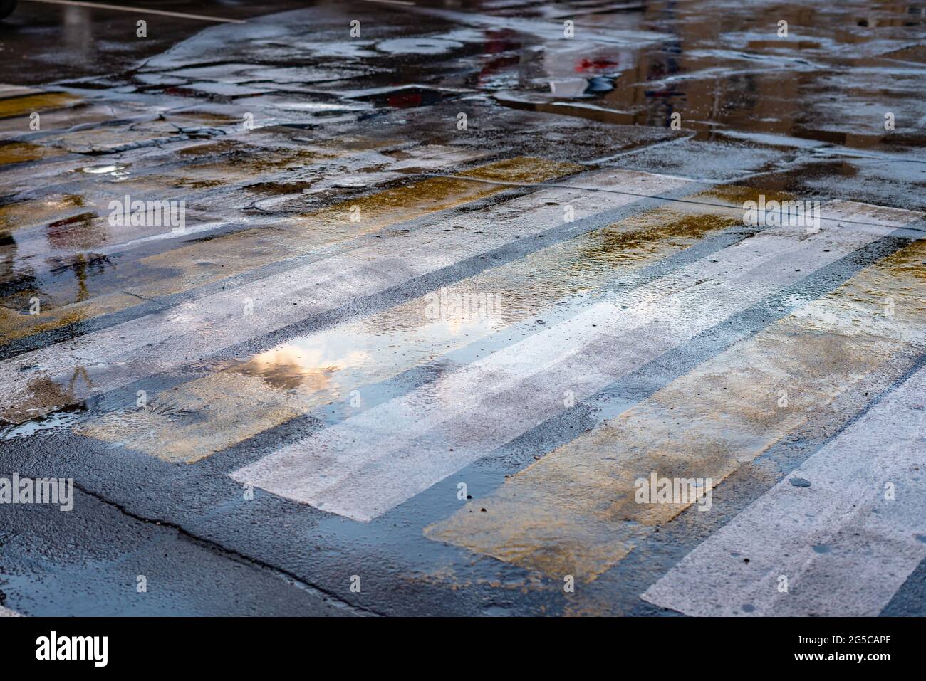 close up wet roadway traffic territory with puddles after the rain ...