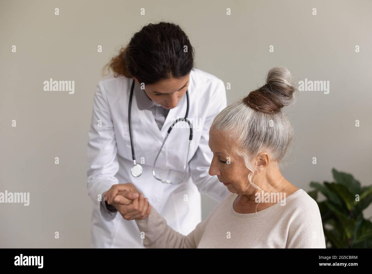 Caring female nurse help old woman patient Stock Photo - Alamy