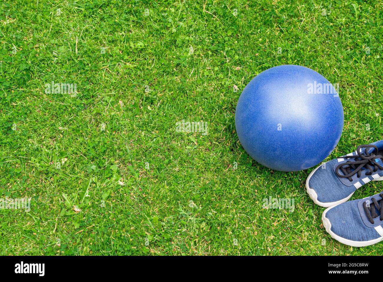 Fitness ball and sneakers on the green grass background Stock Photo - Alamy