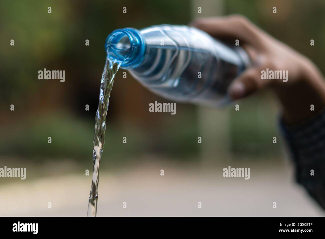 hand holding a plastic bottle and pouring water from it Stock Photo - Alamy