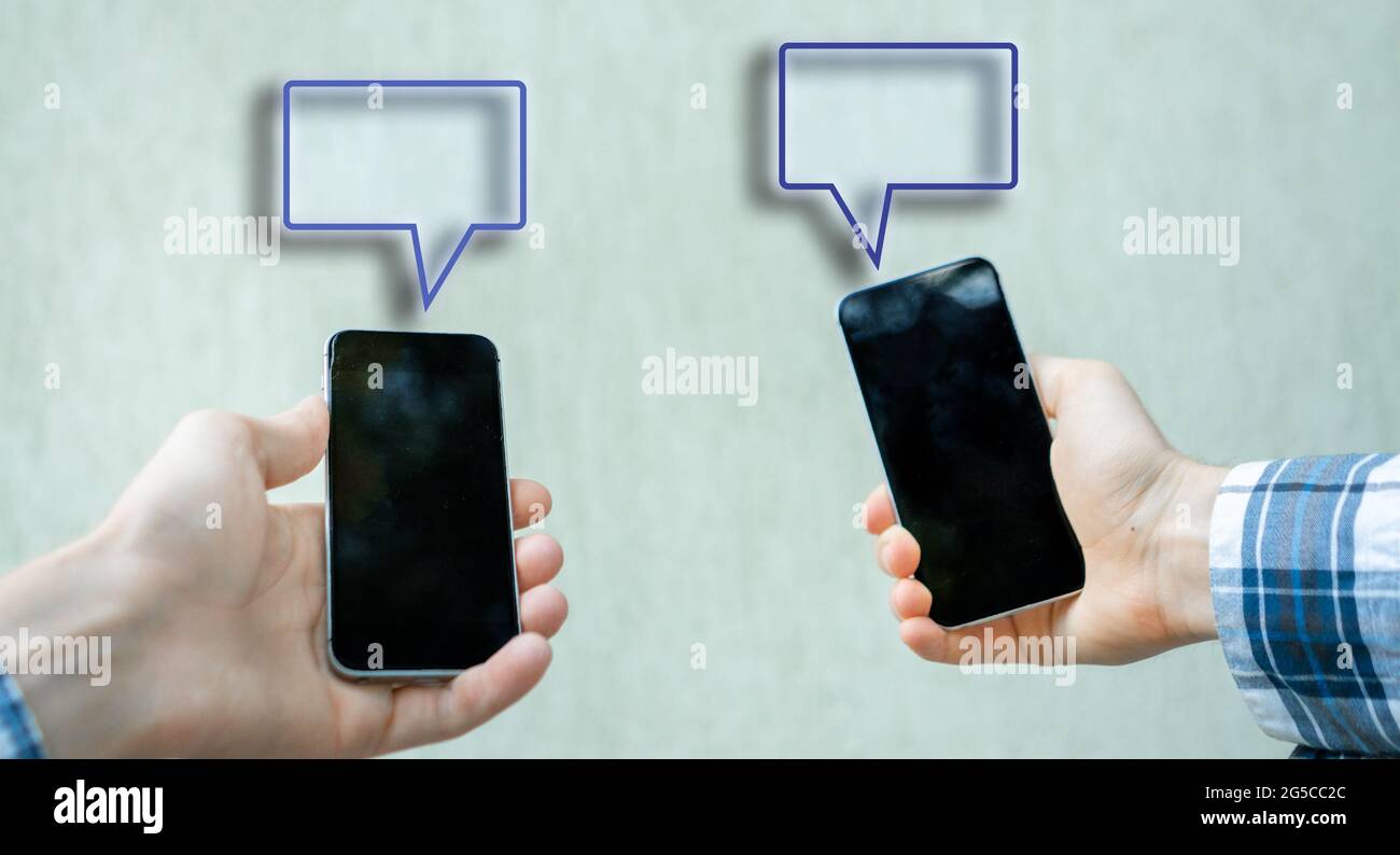 two people holding smartphones and chatting with each other. global ...