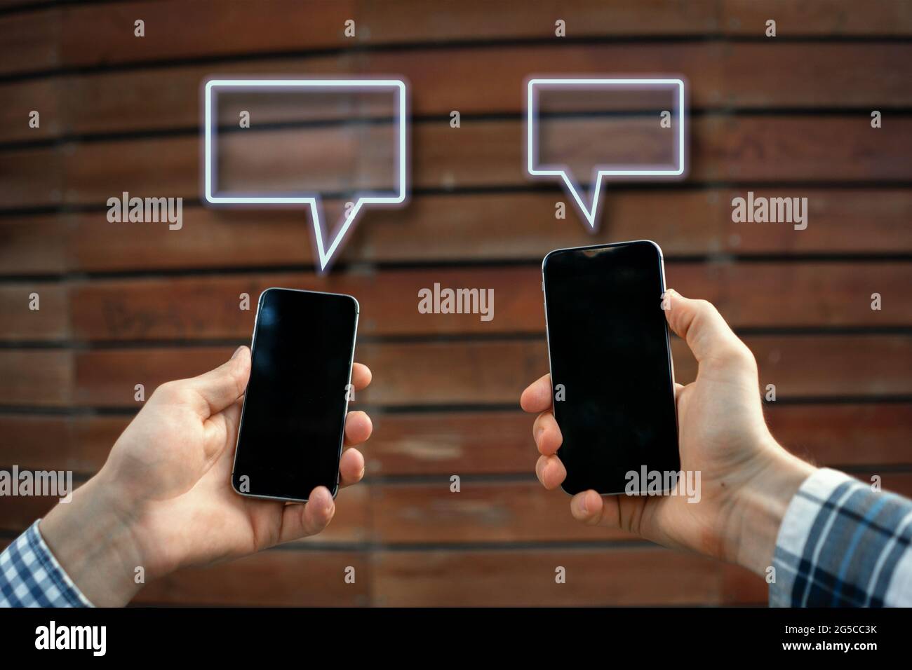 two people holding smartphones and chatting with each other. global ...