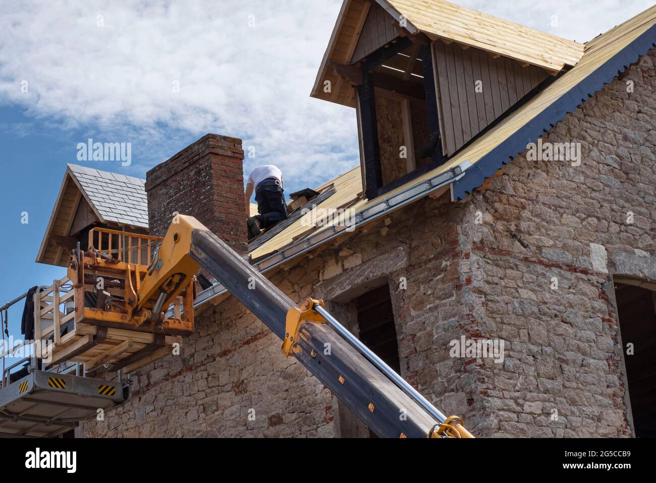 A roofer renovates the roof of an old Breton stone house Stock Photo ...