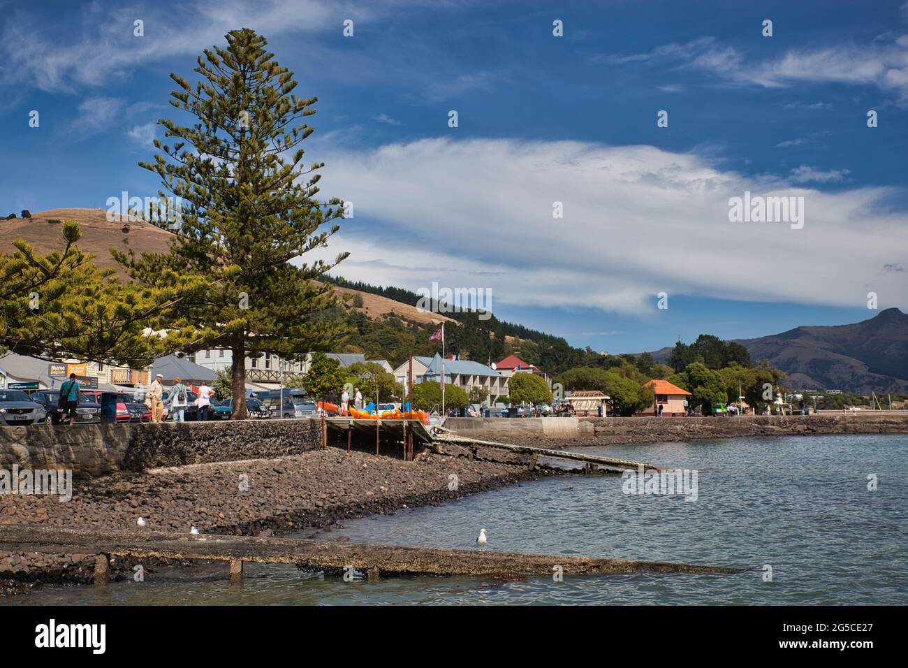 Pretty scene of a waterfront with shops and houses above a beach, on ...