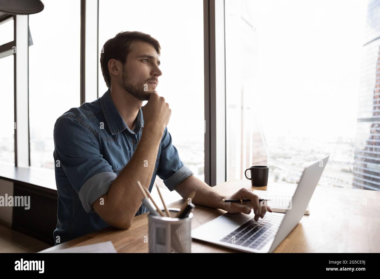 Thoughtful millennial generation male manager working on computer Stock ...