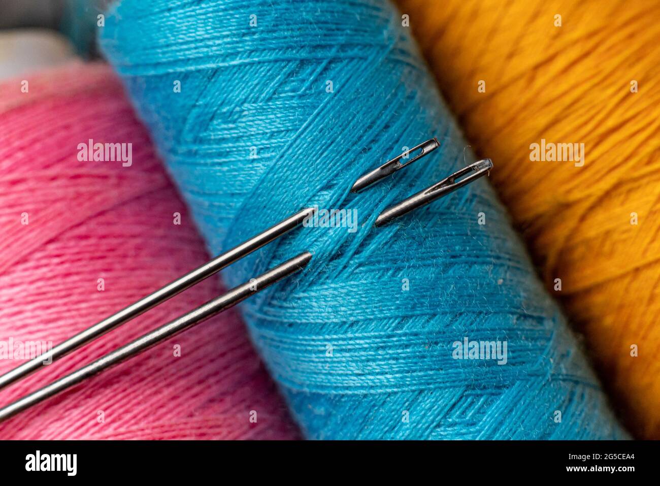 macro shot of needle inserted in the color thread roll Stock Photo - Alamy