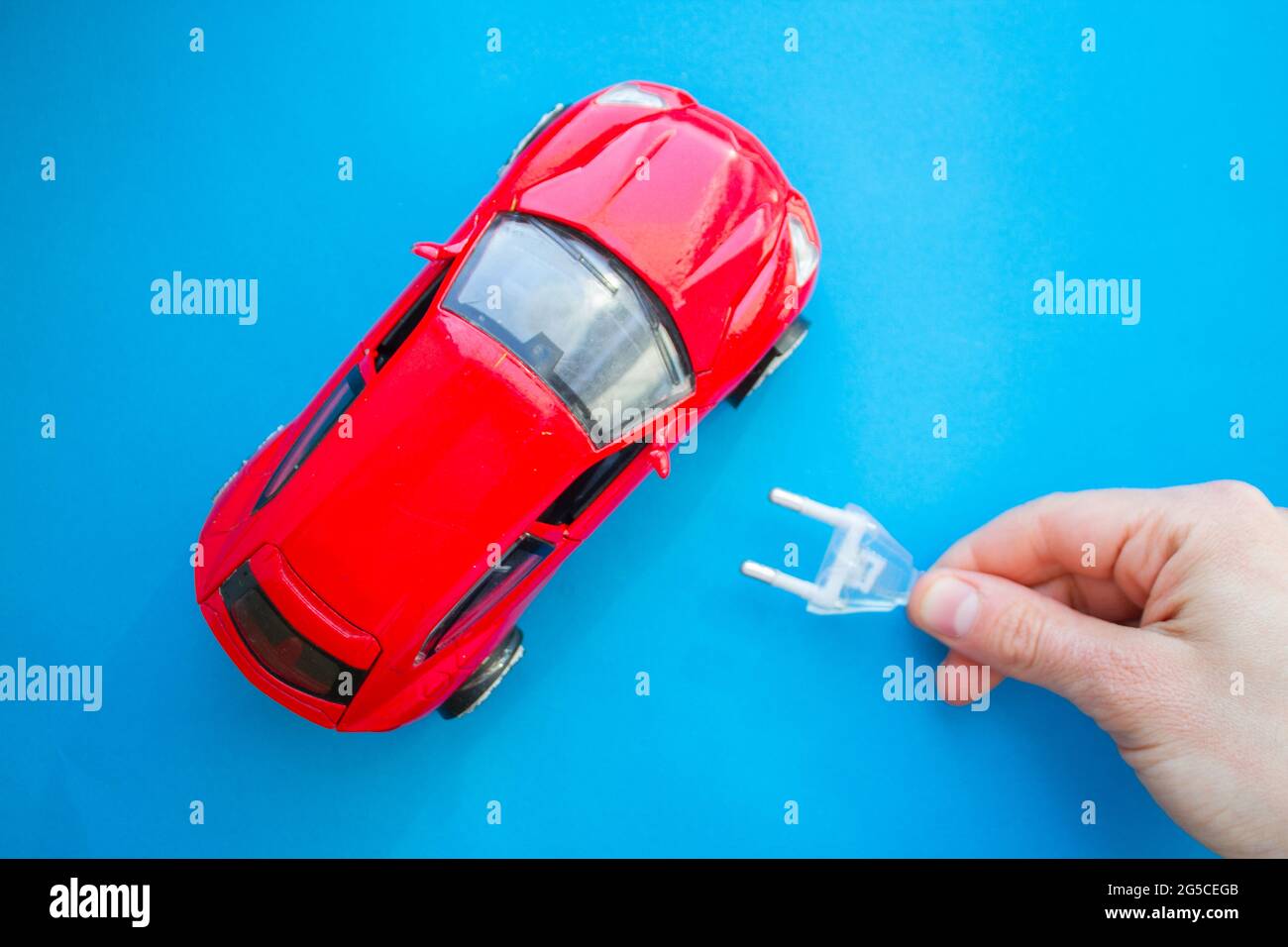 Electric car concept. Toy car and electric plug Stock Photo - Alamy