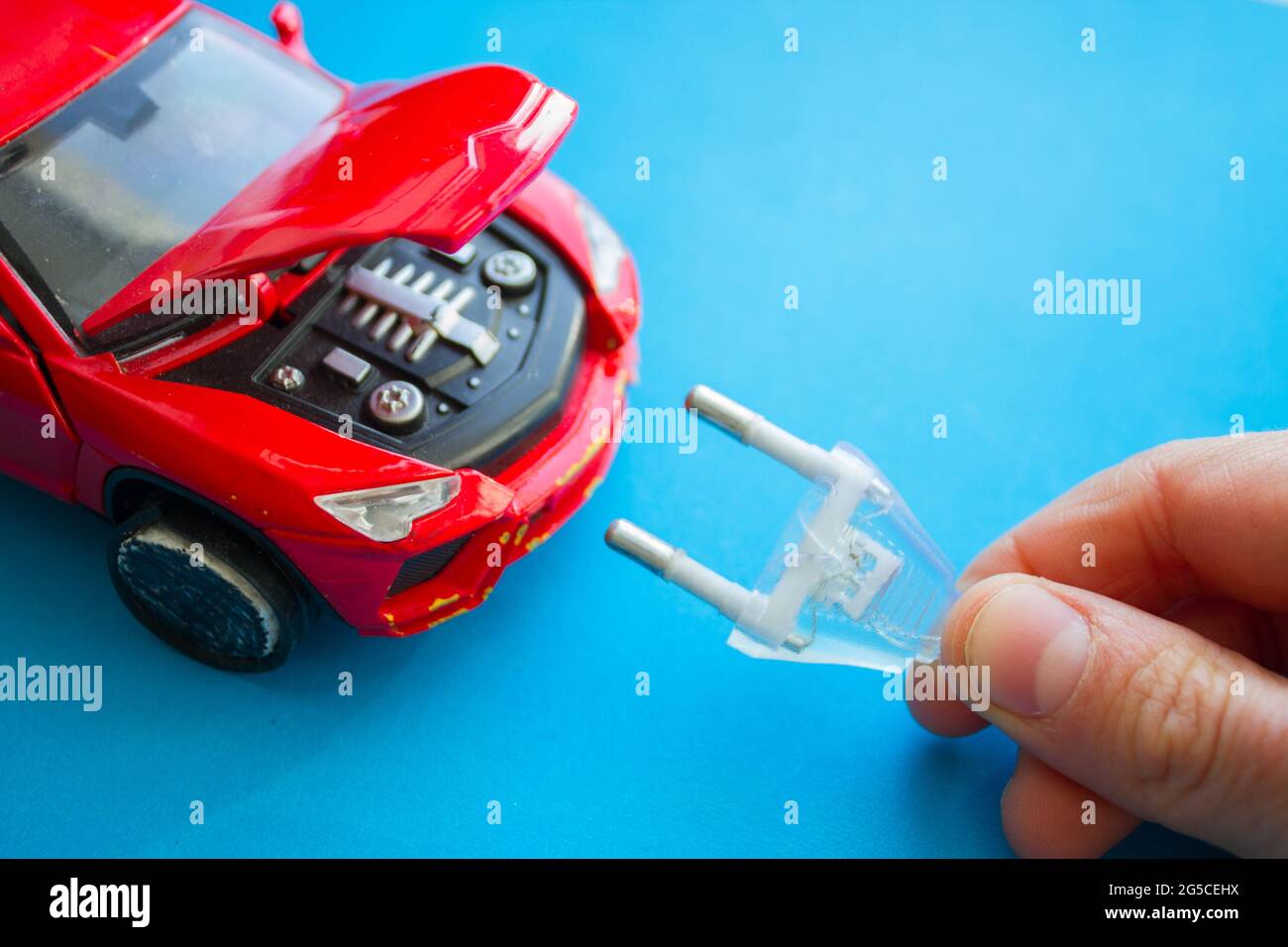 Electric car concept. Toy car and electric plug Stock Photo - Alamy