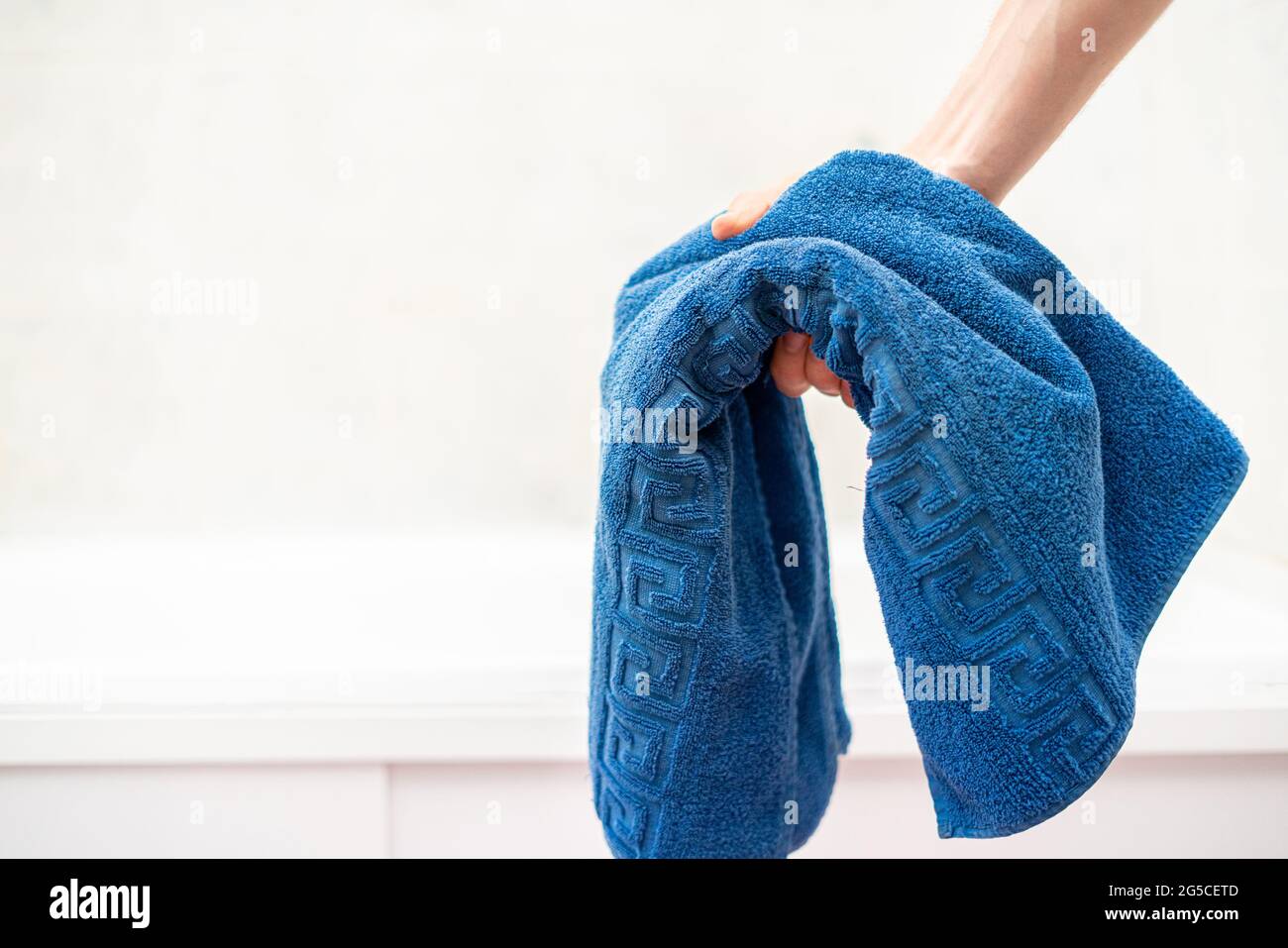 person hand holding a color towel before taking bath Stock Photo - Alamy