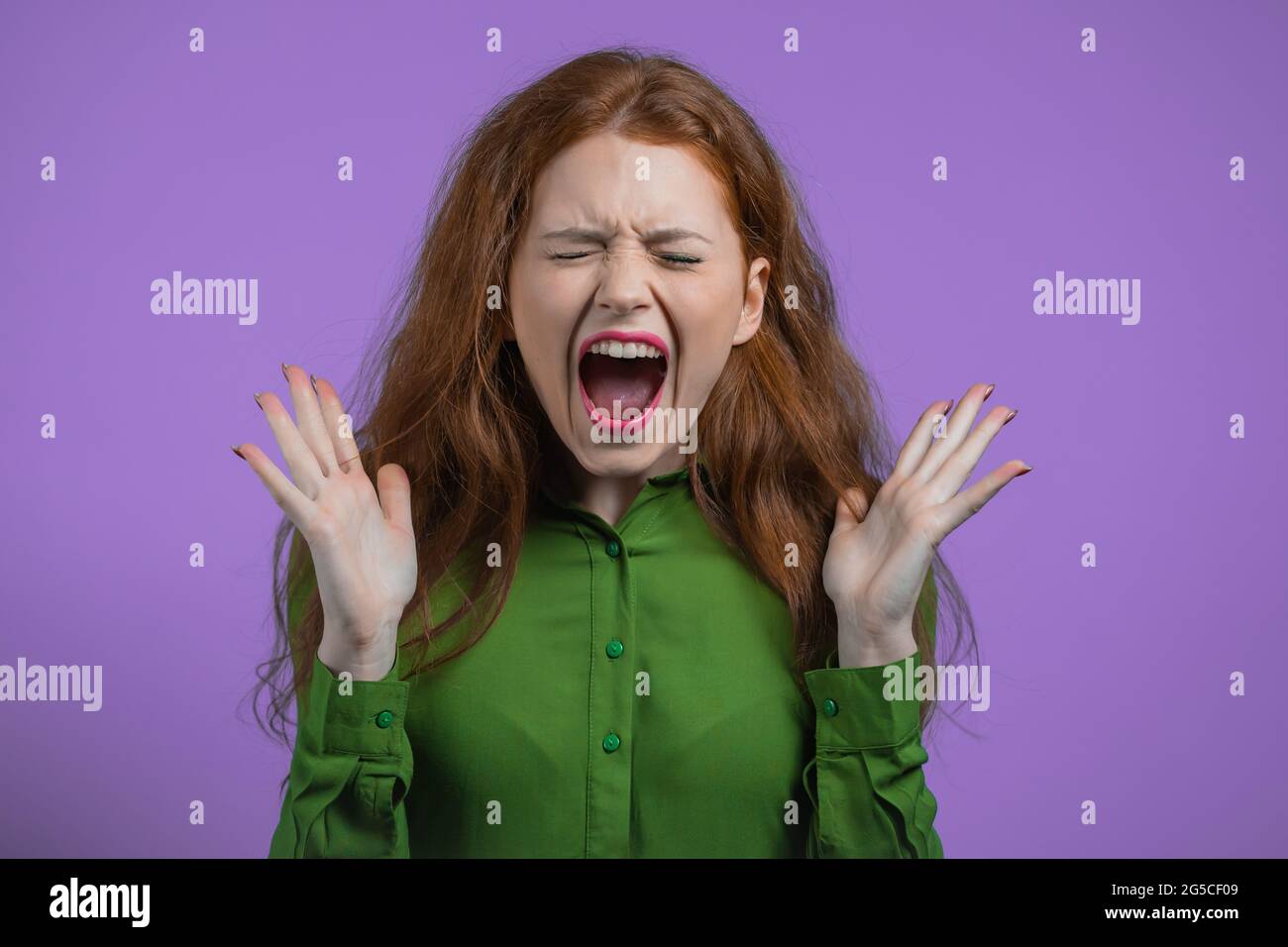 Portrait of unpleasantly surprised and shocked girl on violet studio ...