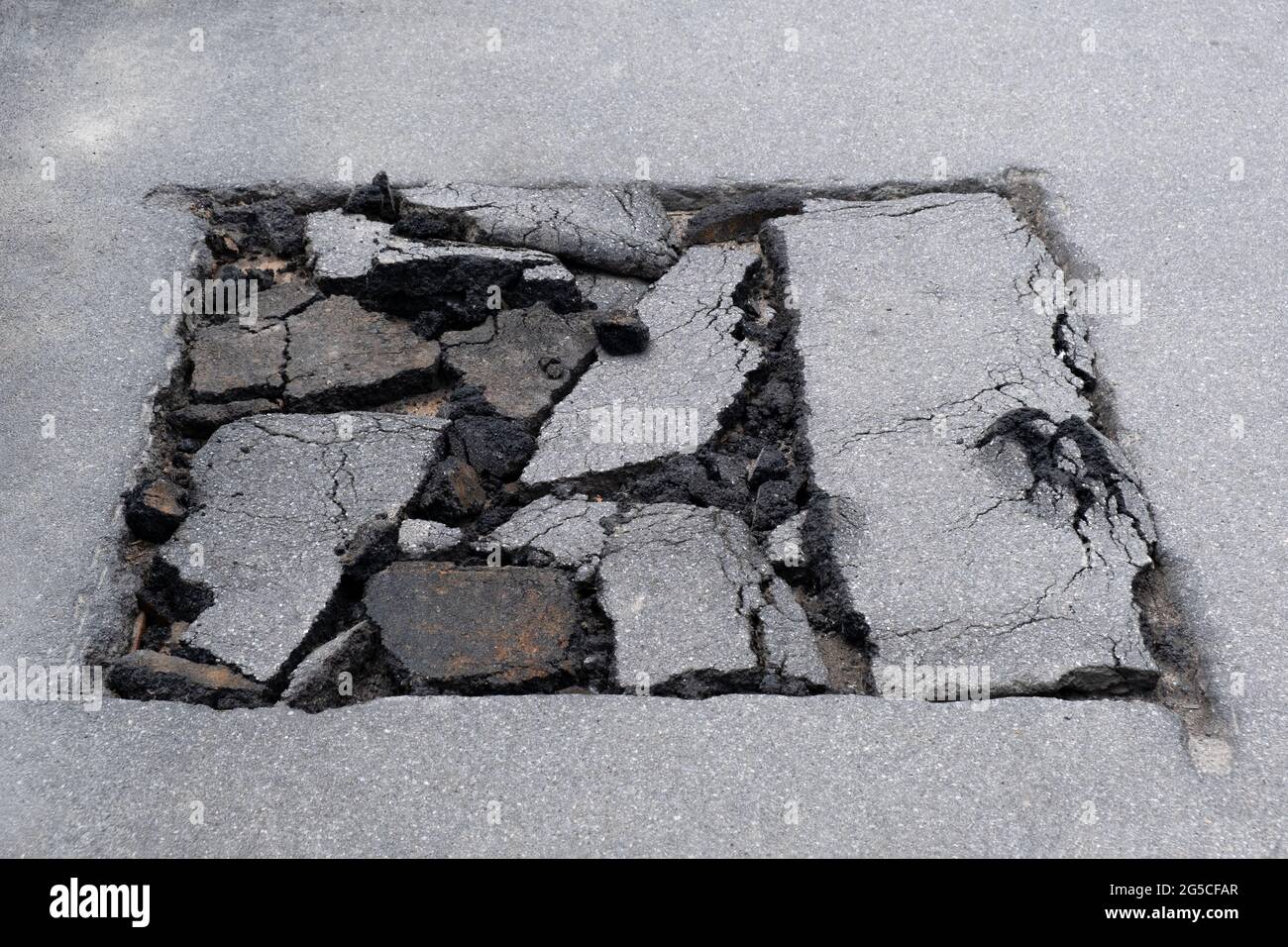 hole in the damaged asphalt. Pothole patching and repair asphalt Stock ...