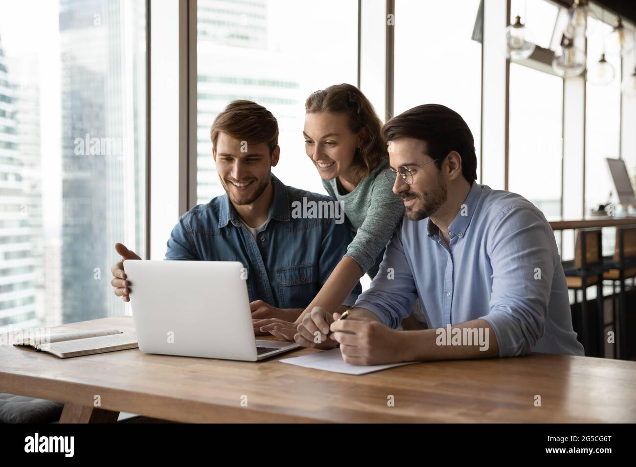Happy three teammates working together on online project Stock Photo ...
