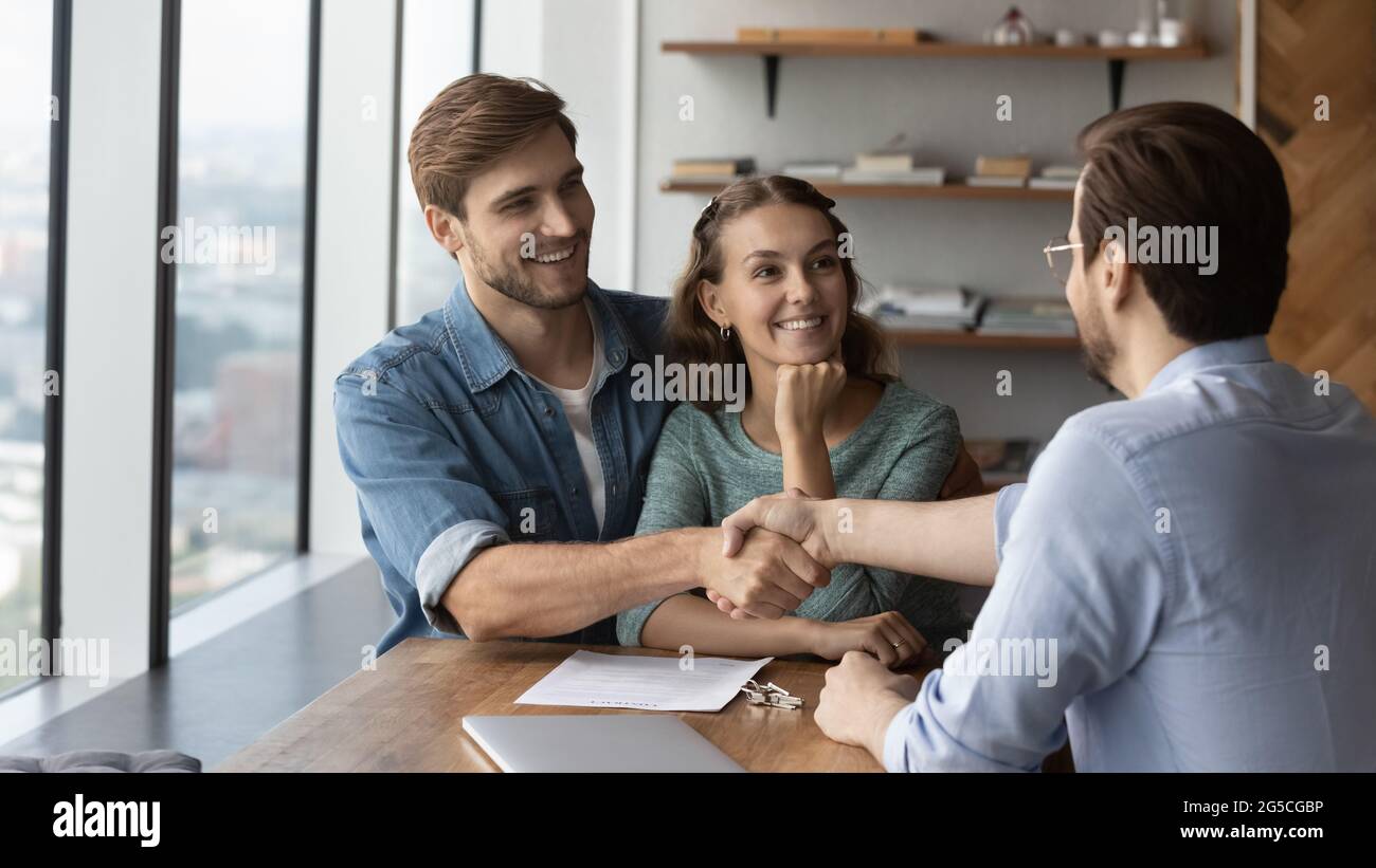 Happy loving married family couple shaking hands with realtor Stock ...