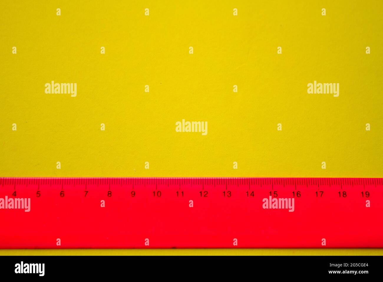 Pink ruler on yellow background. Copy space Stock Photo - Alamy