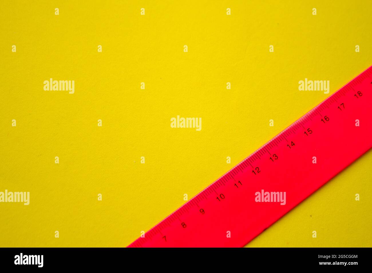 Pink ruler on yellow background. Copy space Stock Photo - Alamy