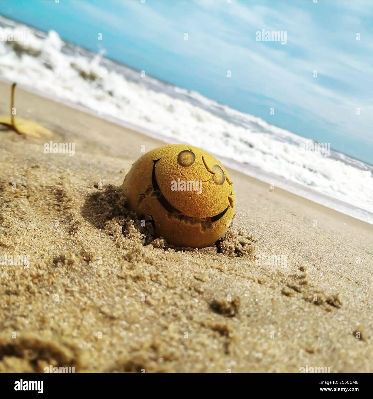Vertical shot of a smiley ball on the sandy beach Stock Photo - Alamy