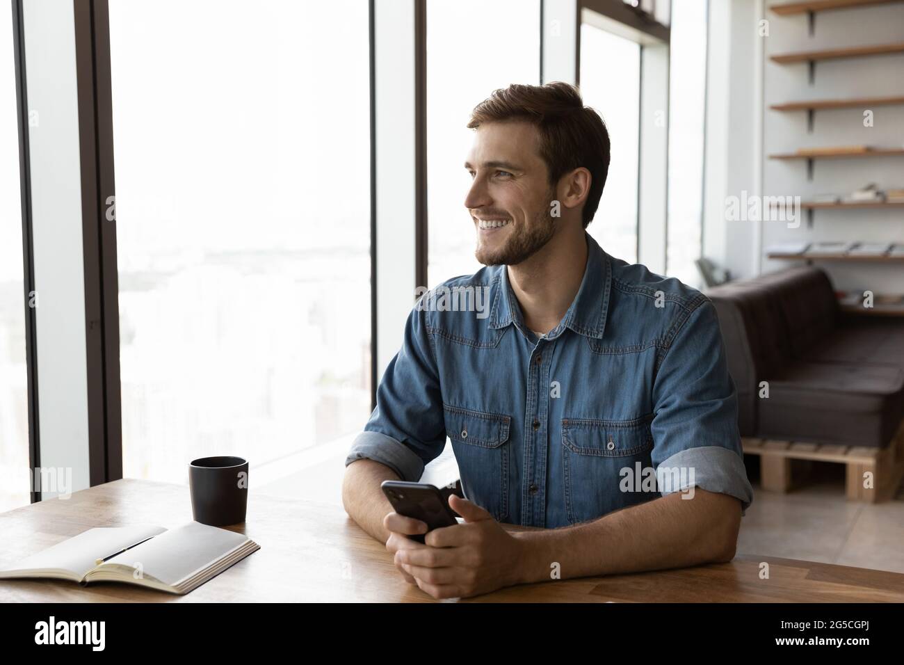 Distracted young man holding smartphone in hands Stock Photo - Alamy