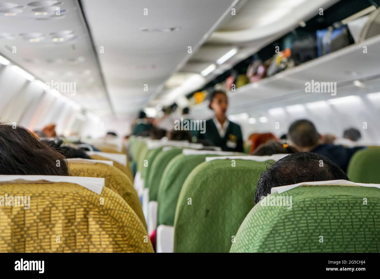 Commercial plane interior before take off, focus on man head at seat ...