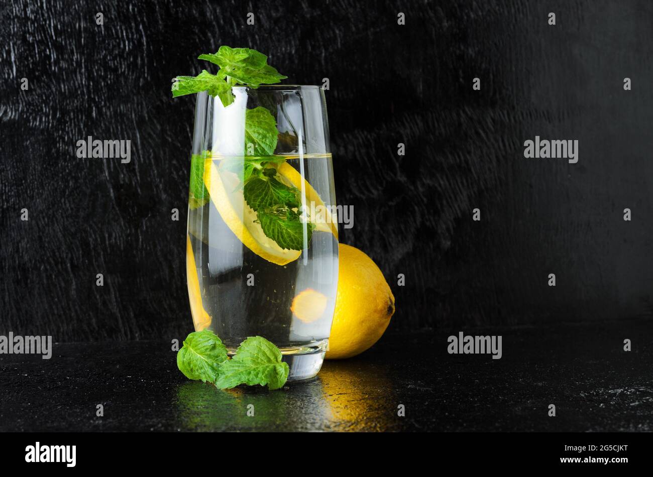 A large glass of water with lemon, mint leaves. A glass of lemonade on ...