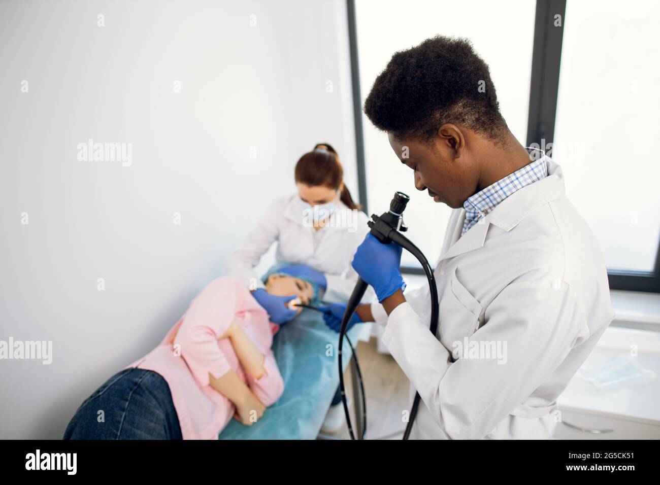Close up of male Afro-American doctor with an endoscope and female ...
