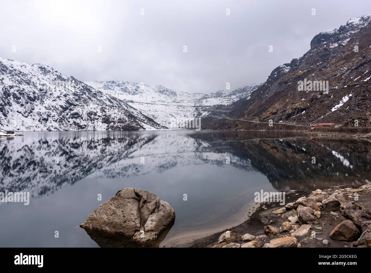 Frozen lake in winter with snow in high mountains with reflection in ...
