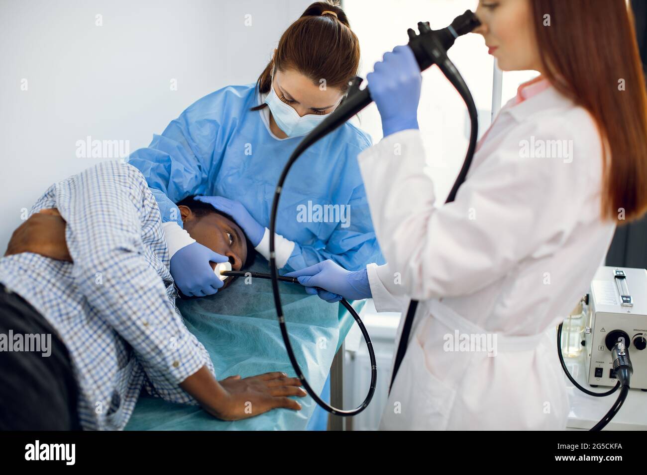 Male African patient having endoscopy in modern clinic. Two ...