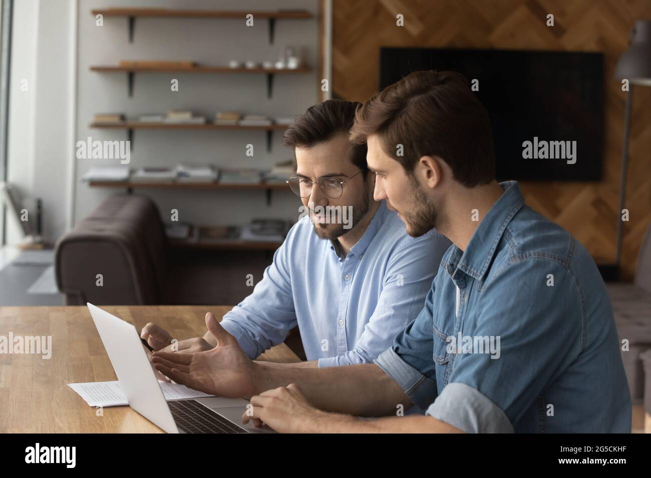Concentrated two male teammates working on computer Stock Photo - Alamy