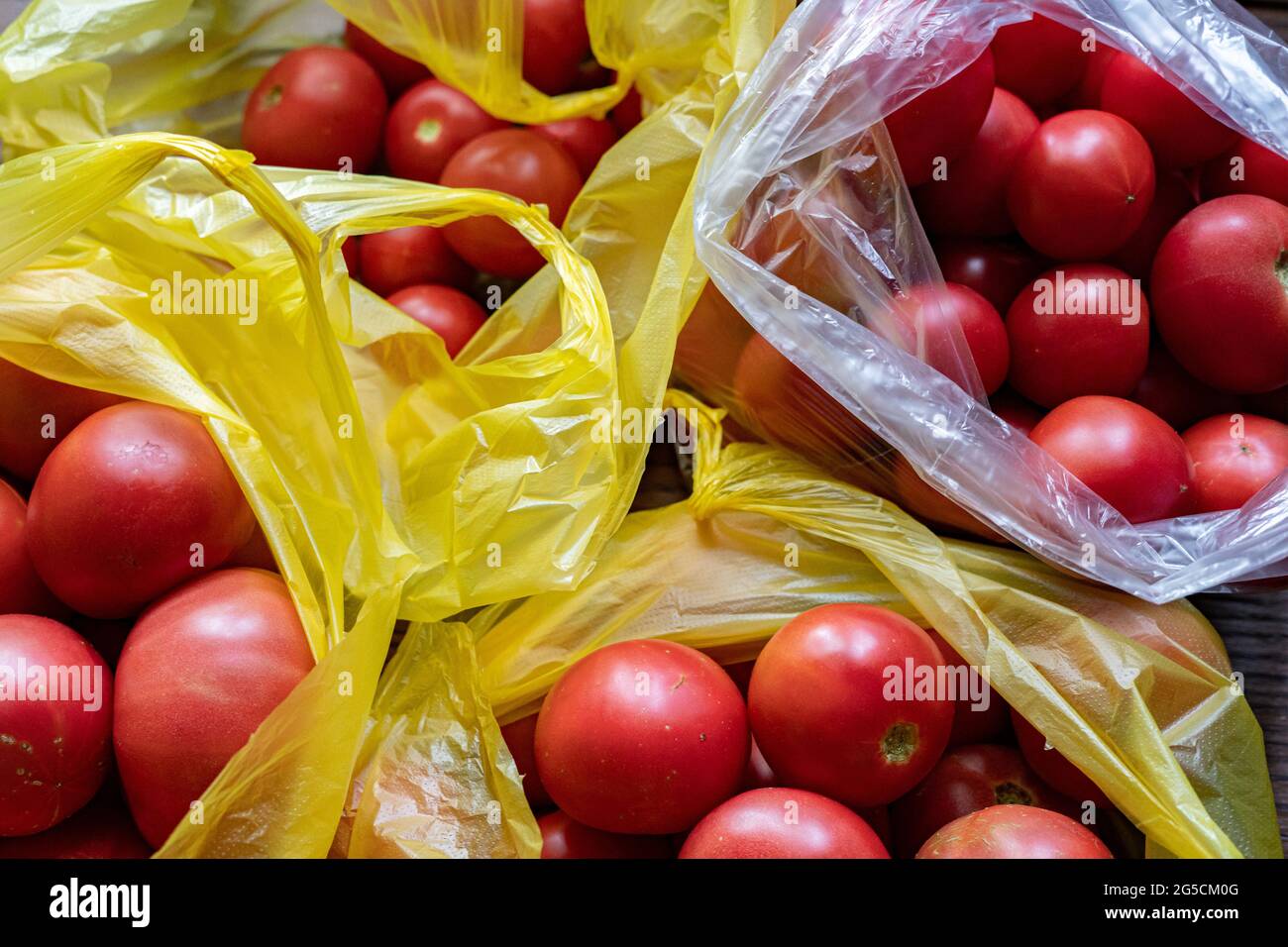 a top view of many red tomatoes in the plastic package begs, the ...