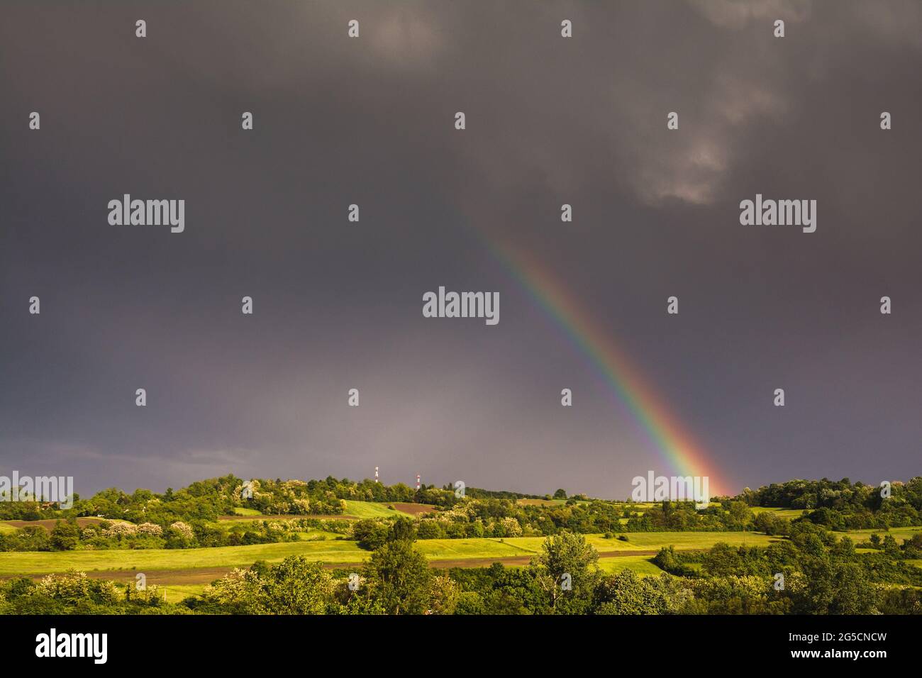 Beautiful view of a rainbow in the gloomy sky after the rain over the ...