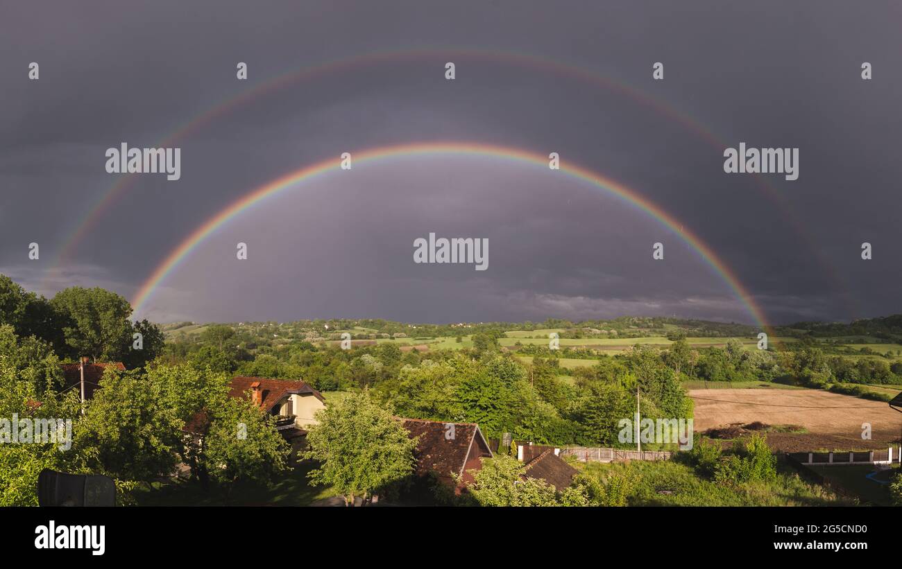 Beautiful view of a rainbow in the gloomy sky after the rain over the ...