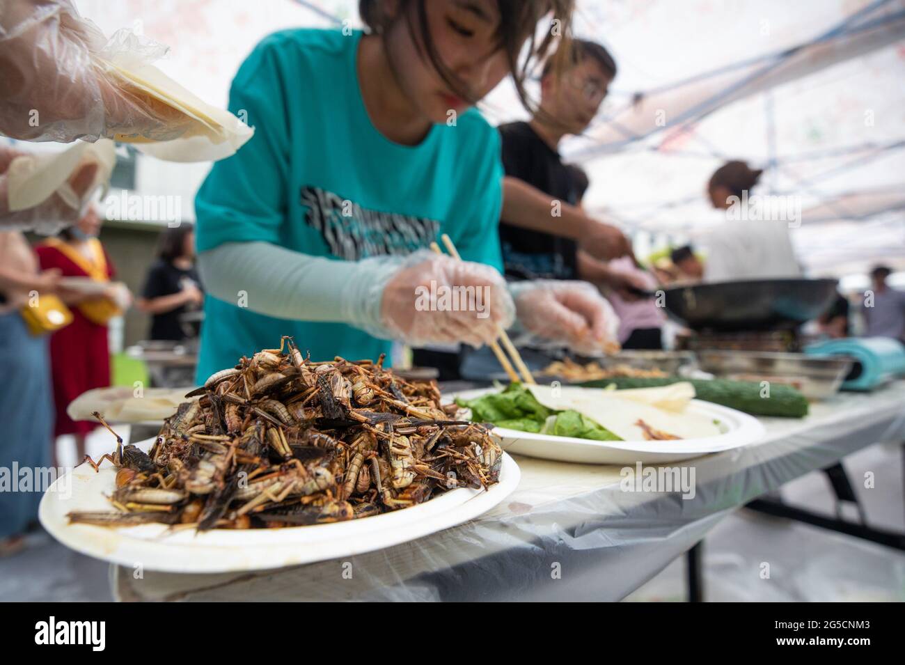 Wuhan, China. 26th June, 2021. College students taste food cooked with ...
