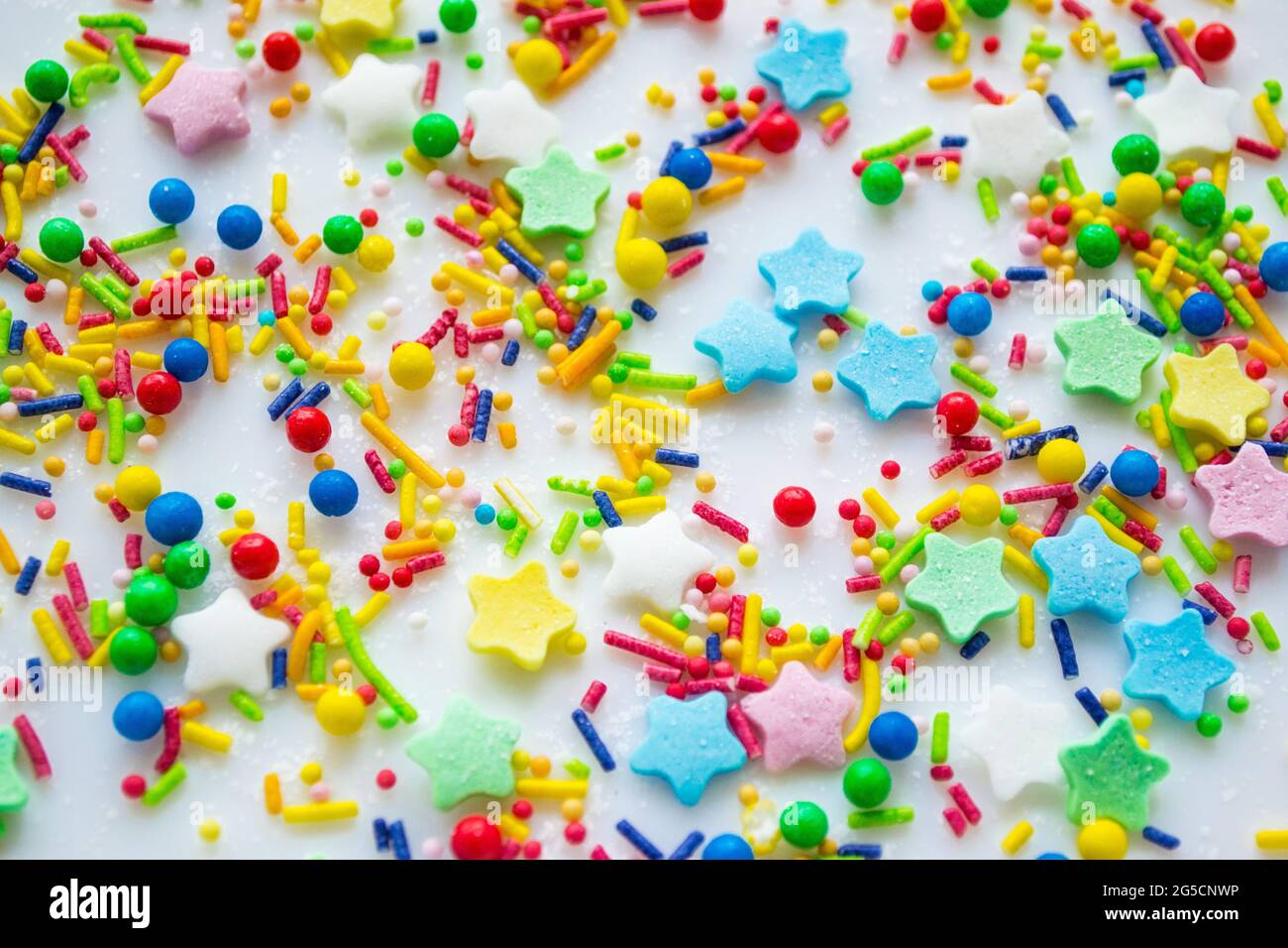 Multi-color festive background of a scattering of sugar candy sprinkles ...