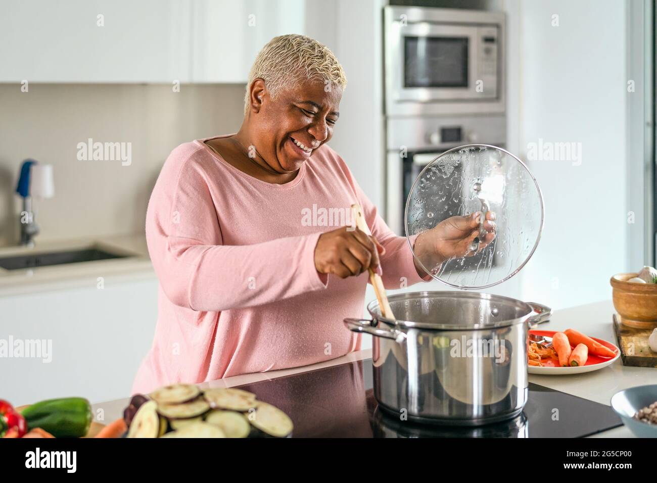 Black woman cooking in kitchen hi-res stock photography and images - Alamy