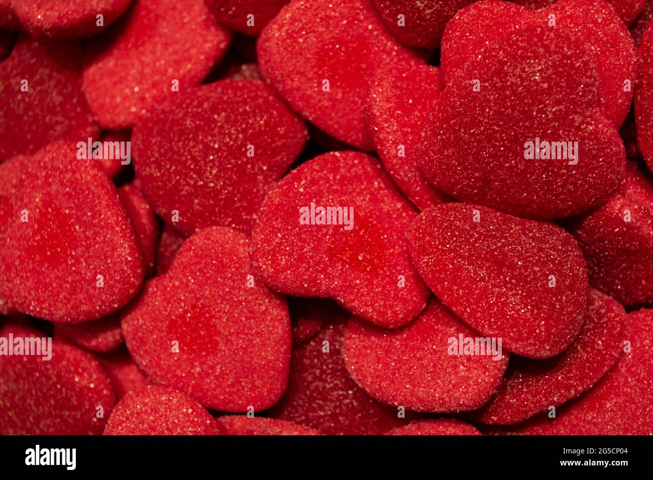 Close-up of a lot of red gelatin candies in the shape of a heart. Sweet ...