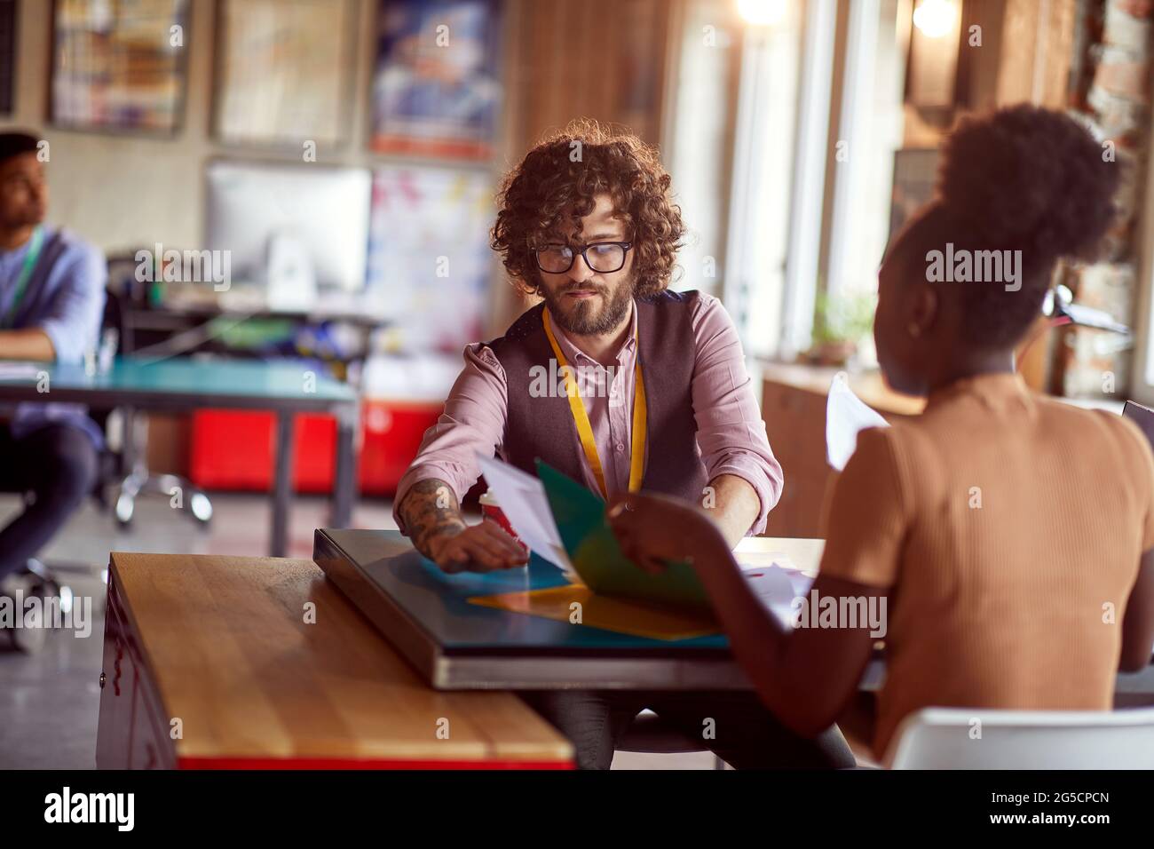 Young colleagues in a team work at desk in a pleasant atmosphere in the ...