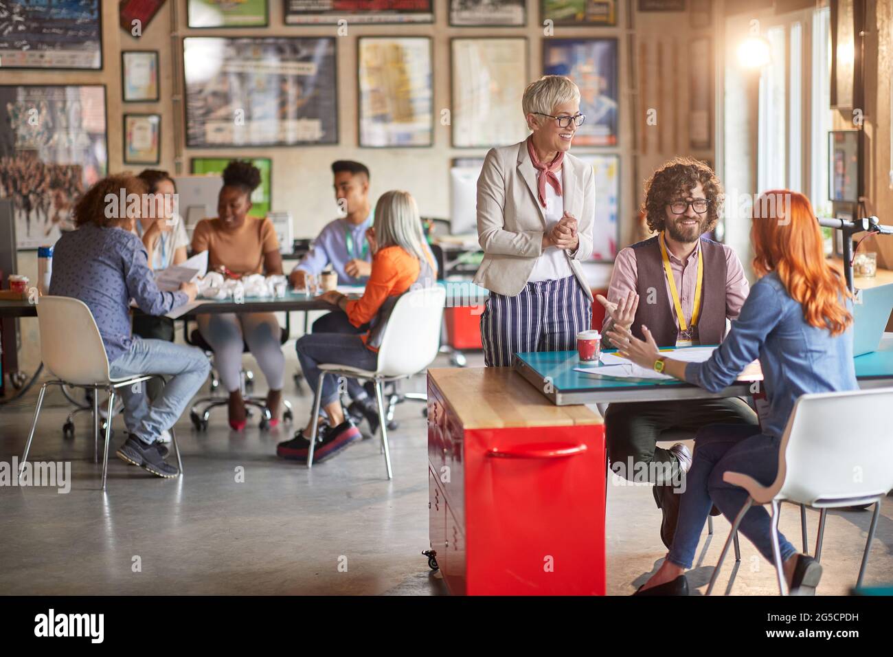 Group of young creative employees and their female boss in a working ...
