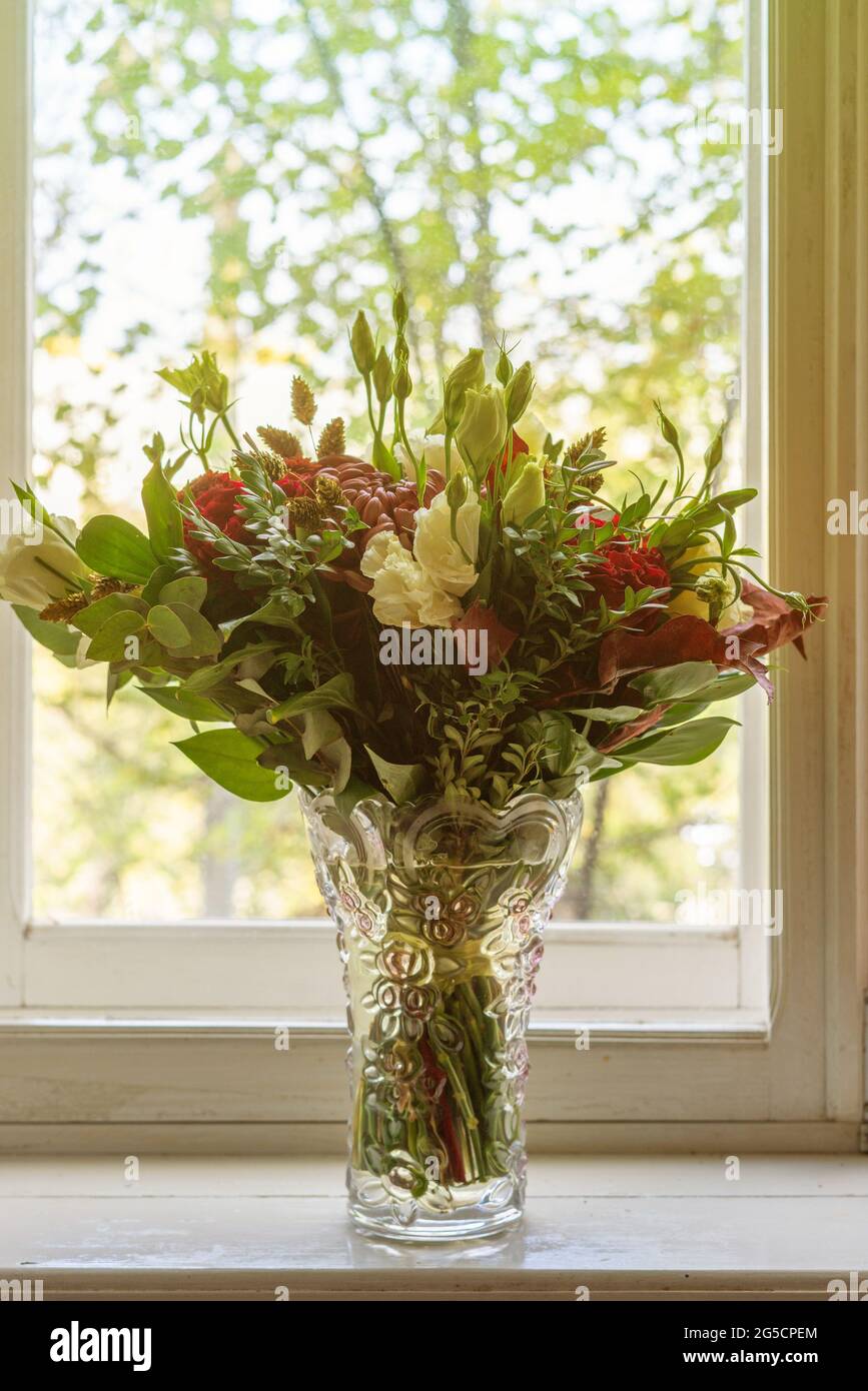 a gorgeous bouquet of the various flowers standing next to the window ...
