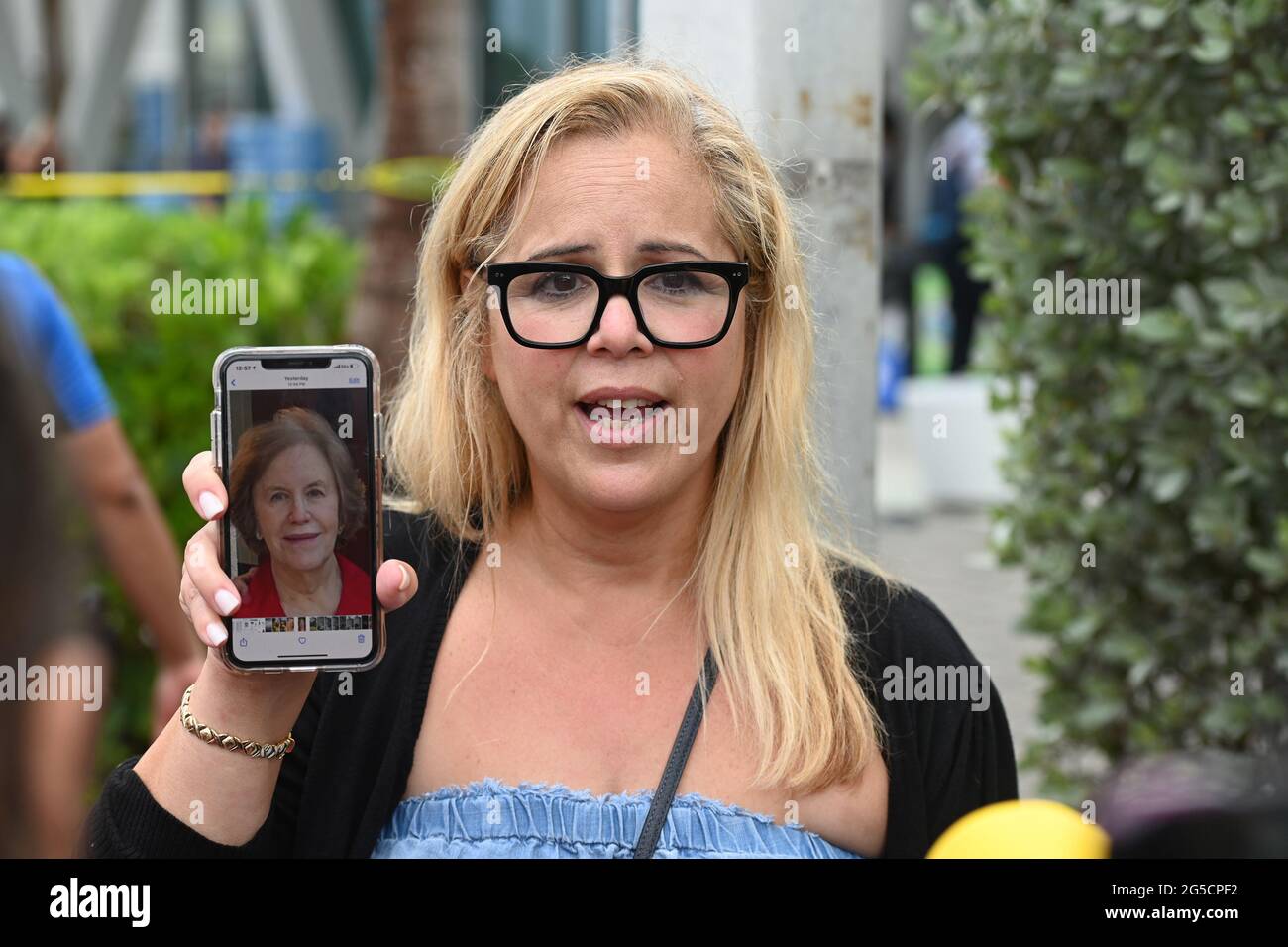 Surfside FL, USA. 25th June, 2021. Magaly Ramsey holds up a photo of ...