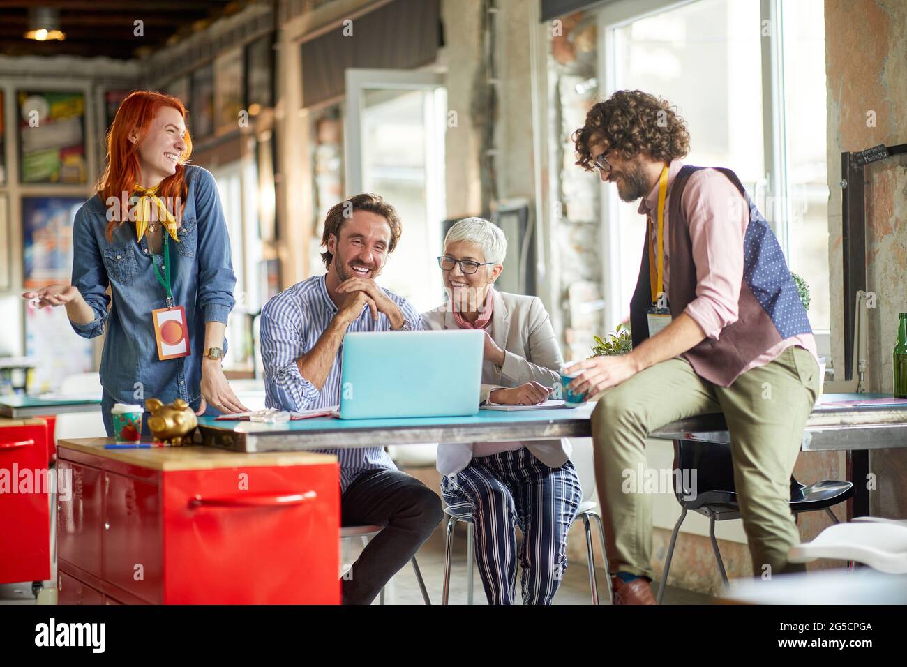 Group of young creative employees is having a good time with their ...