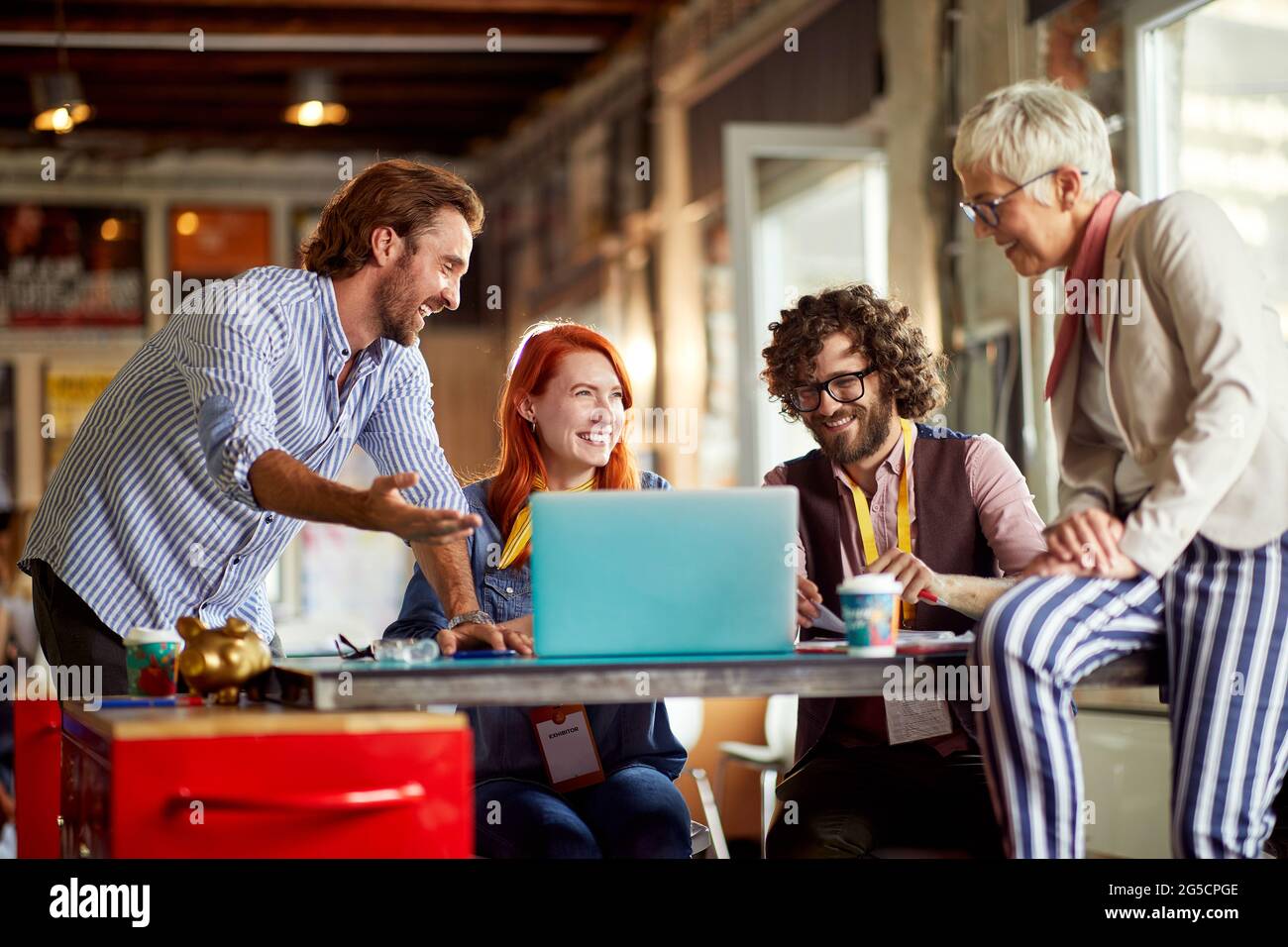 Group of young creative employees is enjoying laptop content with their ...