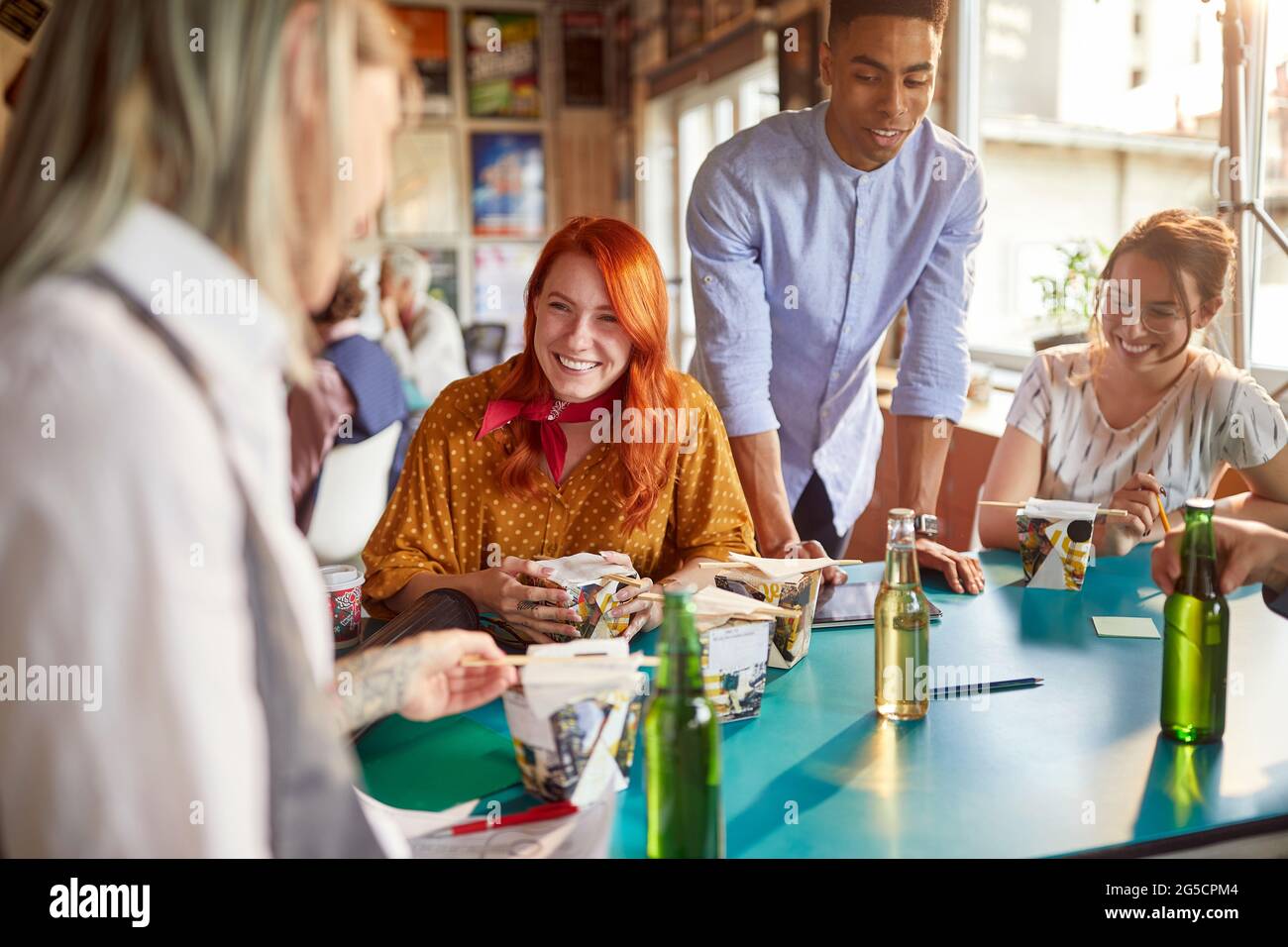 Group of young creative employees is enjoying a lunch break in a ...